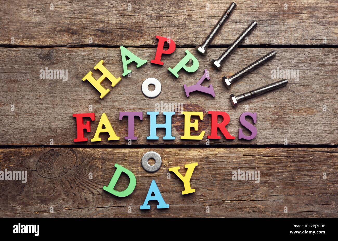 Happy Father's Day inscription with metal bolts on wooden background ...