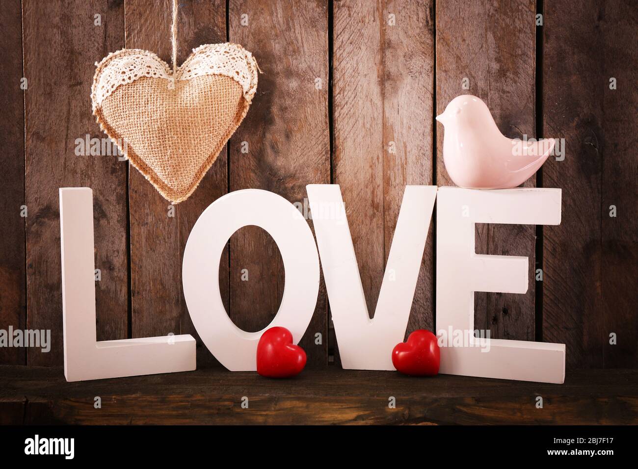 Love word with white letters and hearts on wooden background Stock ...