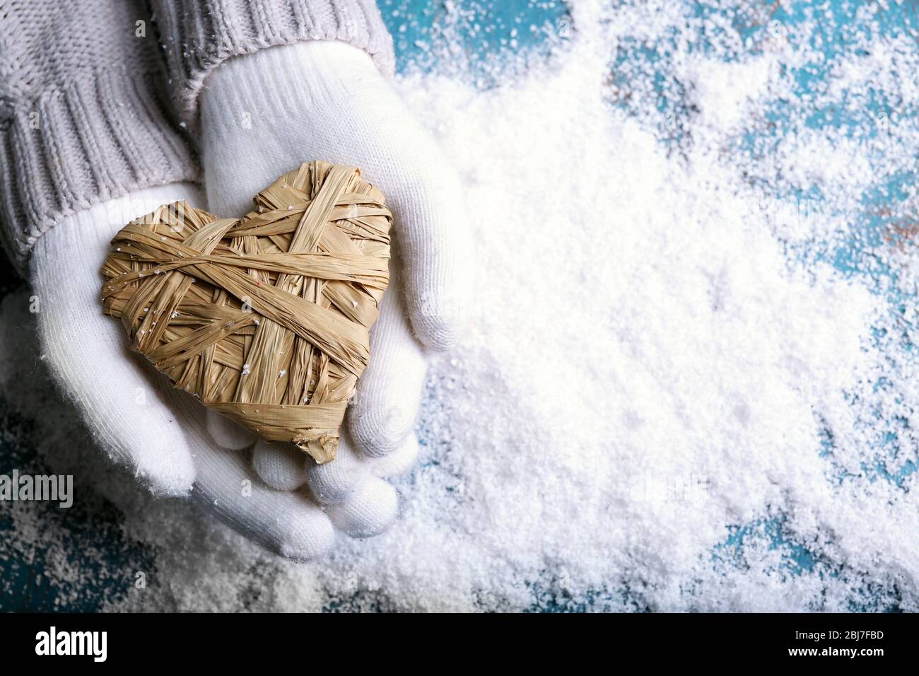 Female hands in mittens with heart on snow background Stock Photo - Alamy