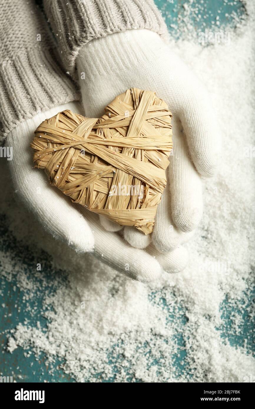 Female hands in mittens with heart on snow background Stock Photo - Alamy