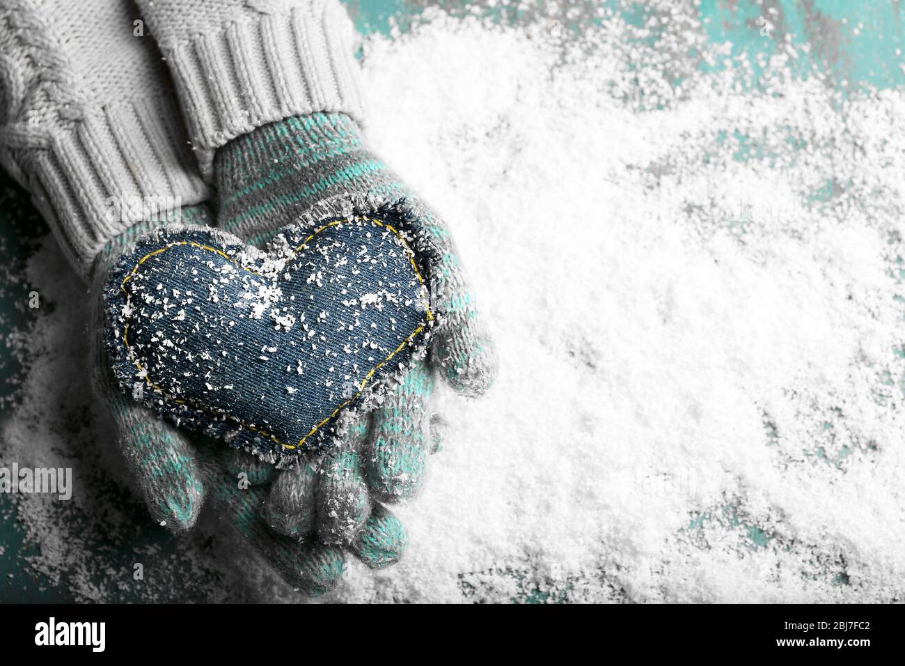 Female hands in mittens with decorative heart on snow background Stock ...