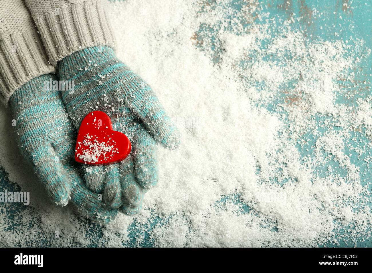Female hands in mittens with decorative heart on snow background Stock ...