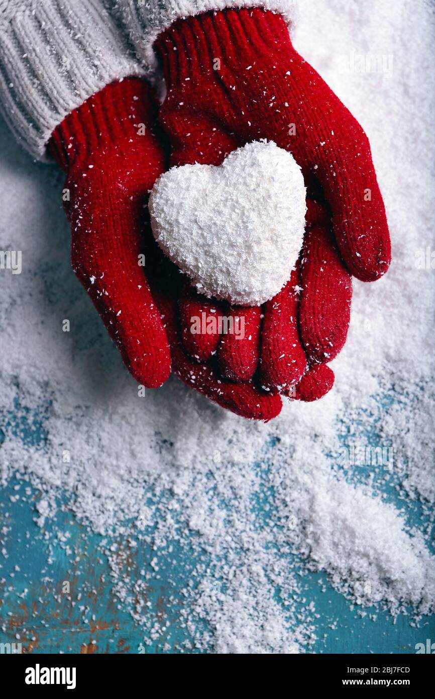 Female hands in mittens with decorative heart on snow background Stock ...