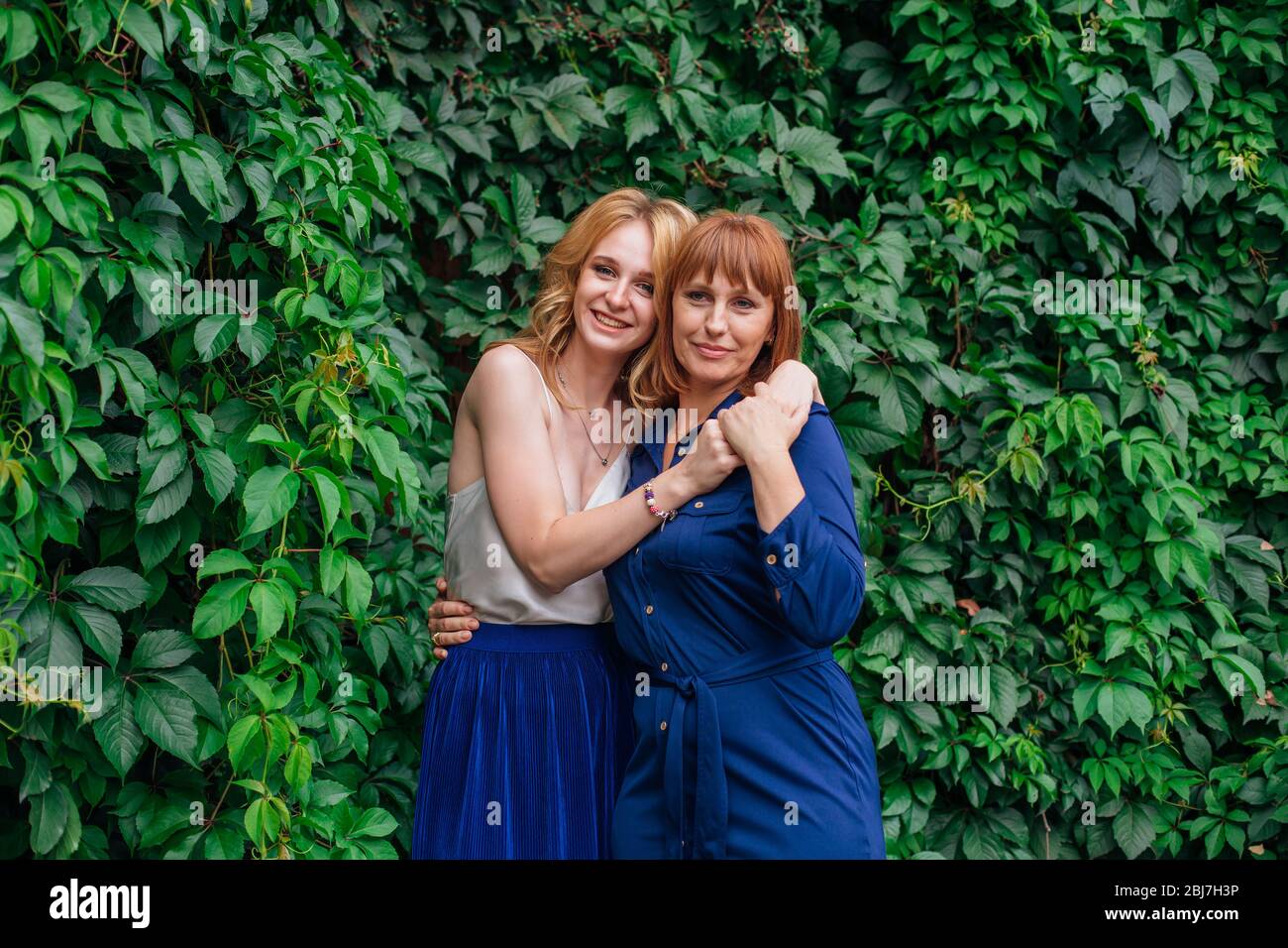 Beautiful mother and her grown up daughter hugging each other on a ...