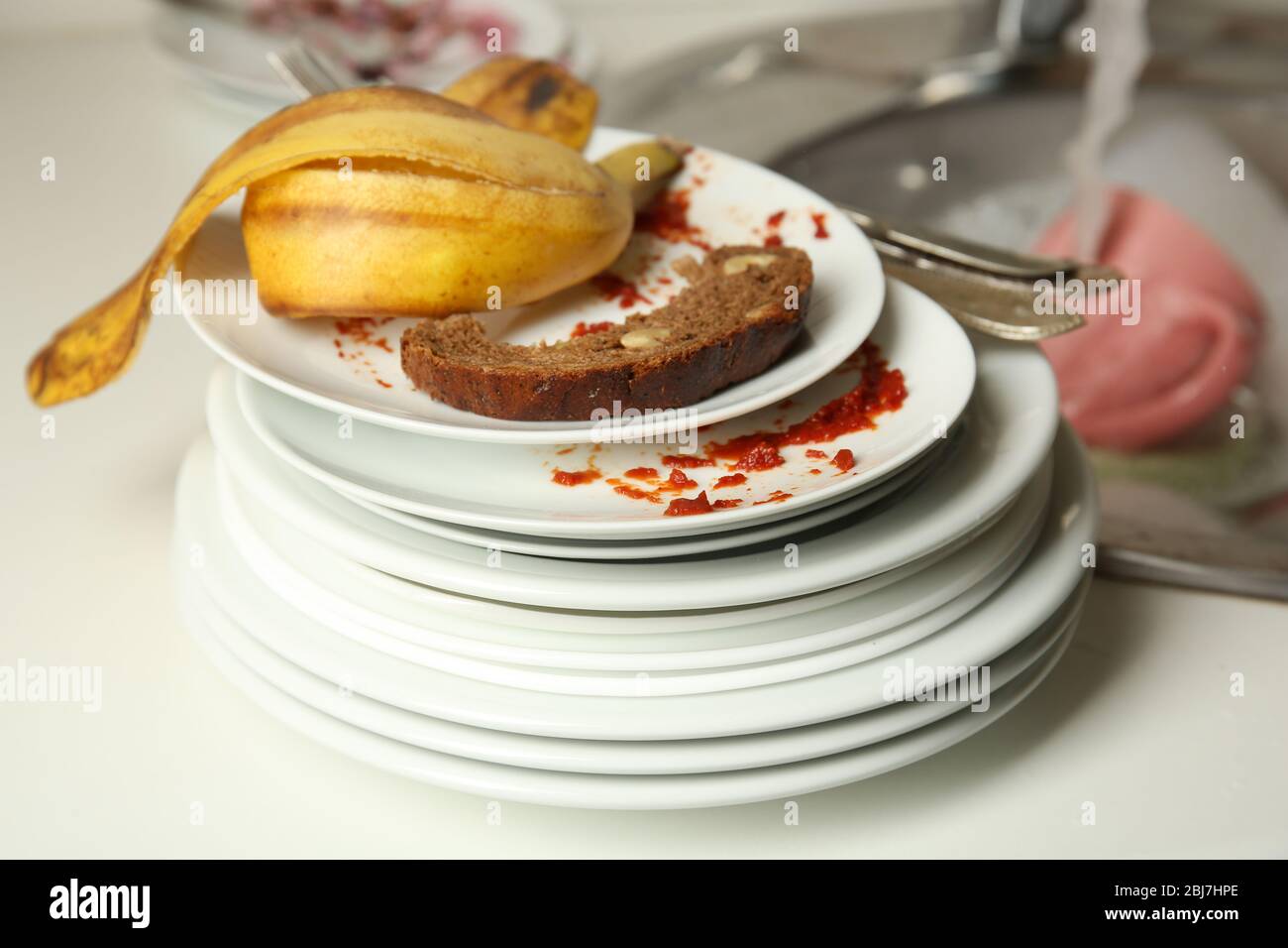 Stack of dirty plates near kitchen sink closeup Stock Photo - Alamy