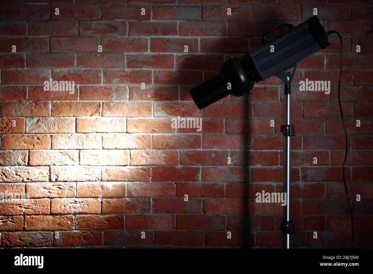 Studio light flash on brick wall background Stock Photo - Alamy