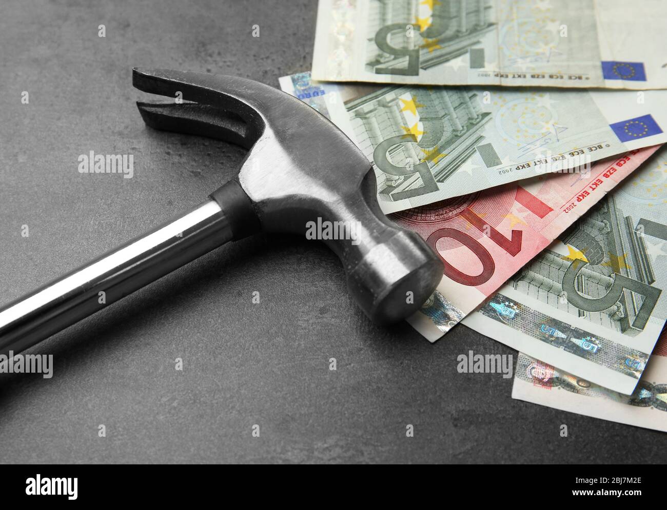 Money with hammer on grey background, close up Stock Photo - Alamy