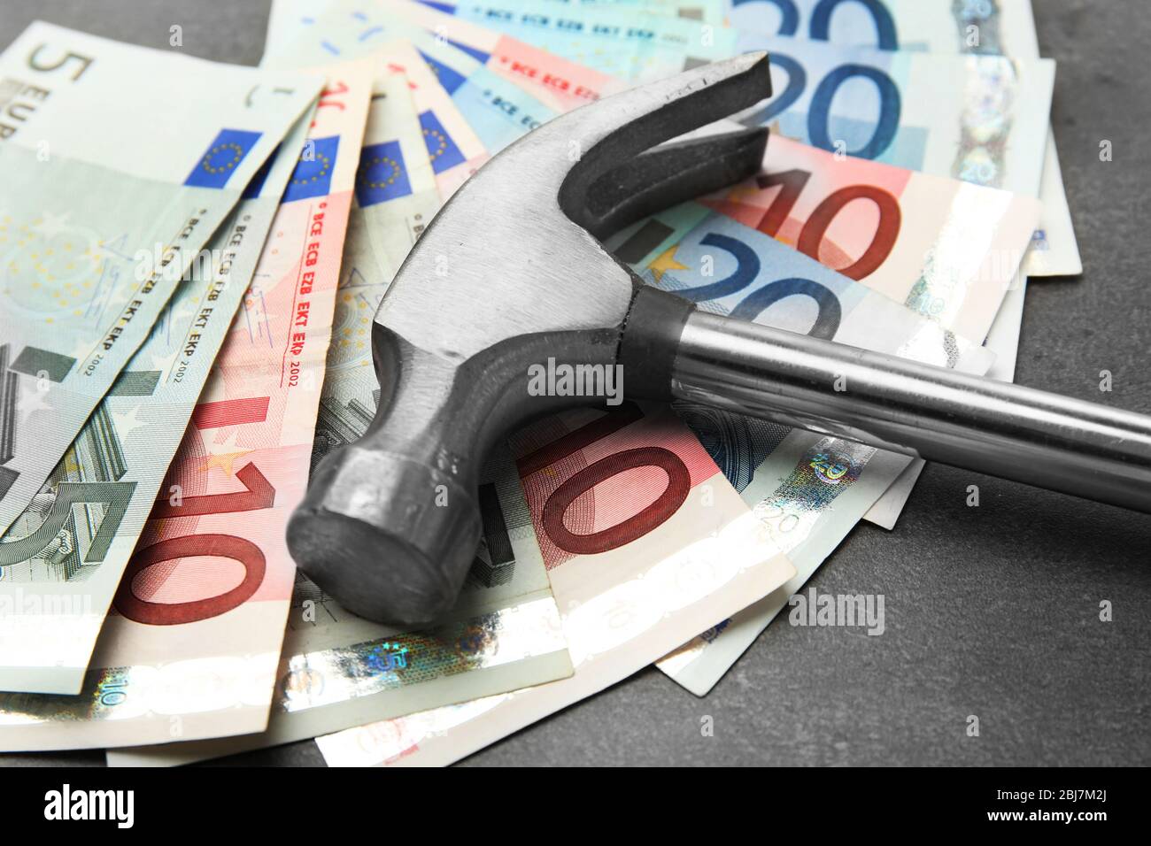 Money with hammer on grey background, close up Stock Photo - Alamy