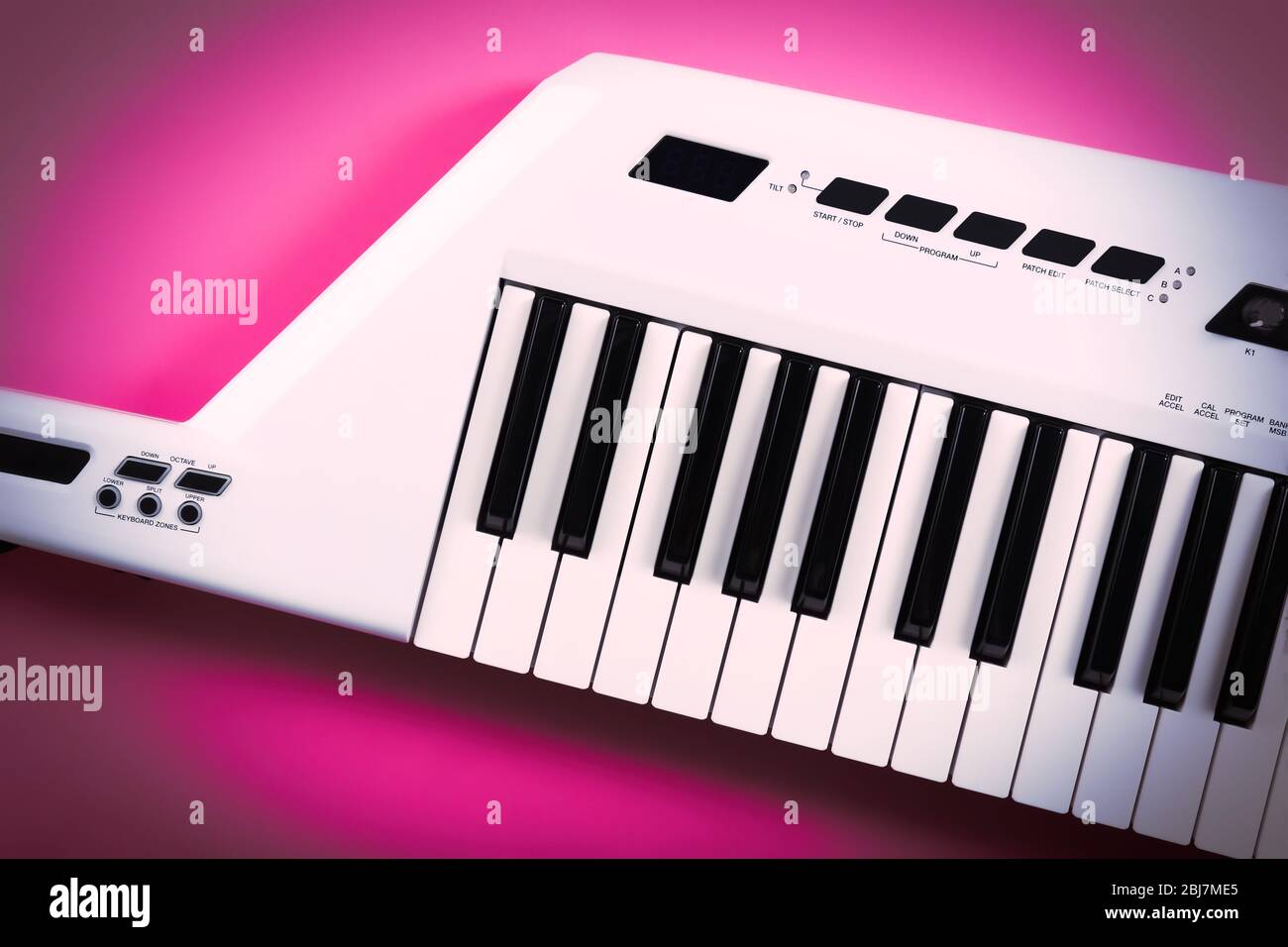 Keyboard of synthesizer on pink background Stock Photo - Alamy
