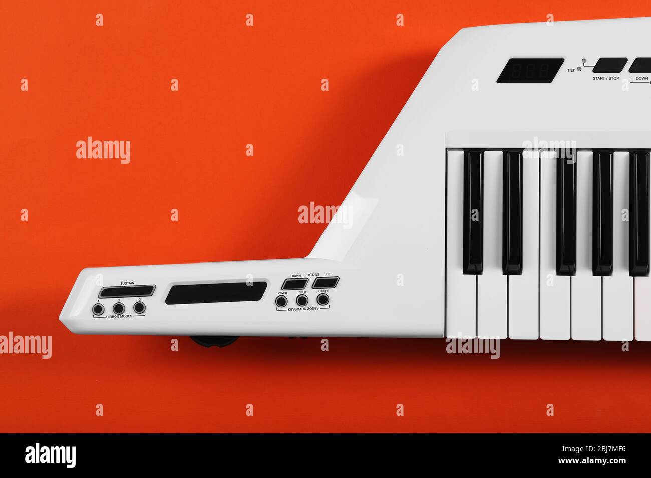 Keyboard of synthesizer on orange background Stock Photo - Alamy