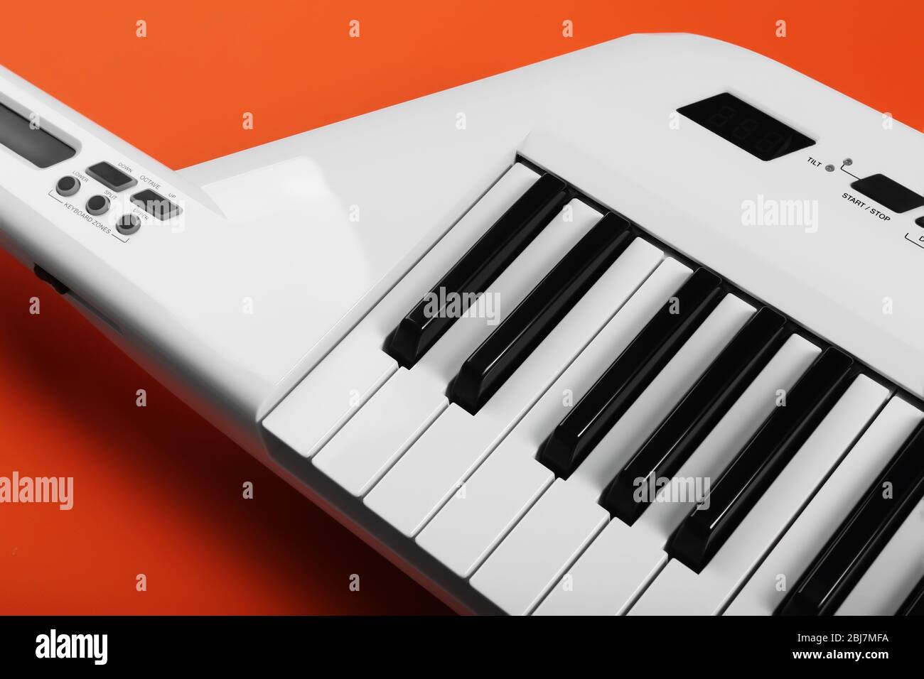 Keyboard of synthesizer on orange background Stock Photo - Alamy