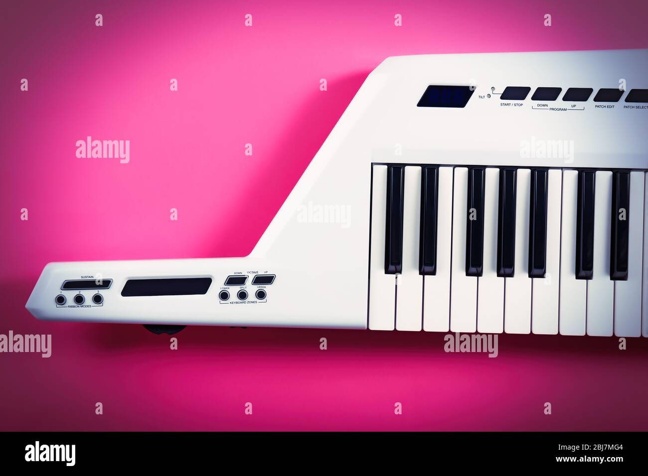 Keyboard of synthesizer on pink background Stock Photo - Alamy