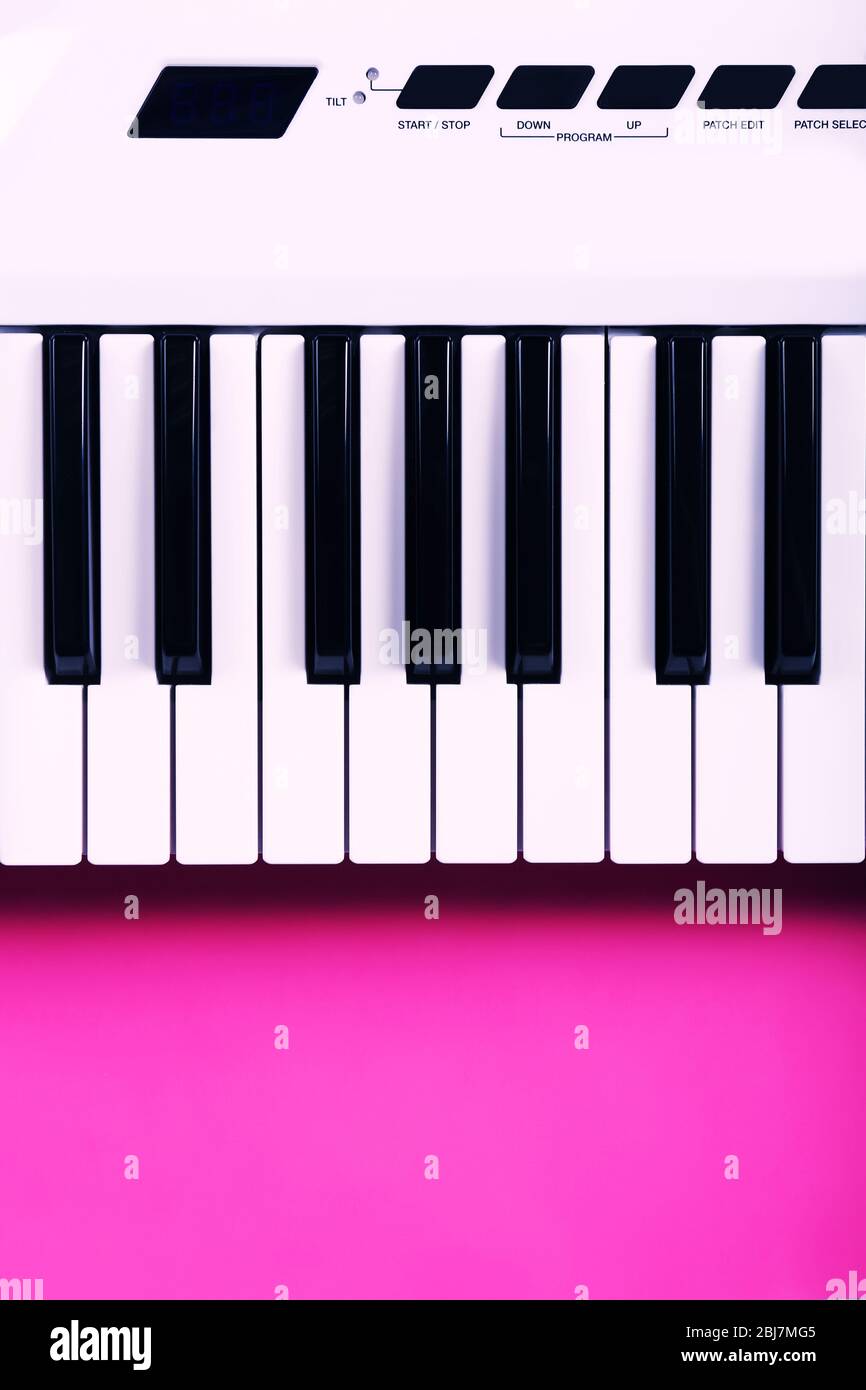 Keyboard of synthesizer on pink background Stock Photo - Alamy