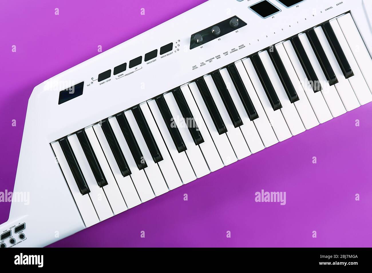 Keyboard of synthesizer on purple background Stock Photo - Alamy
