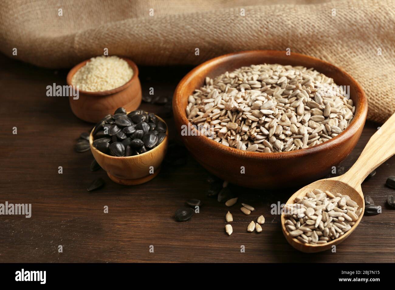 Peeled sunflower and sesame seeds on wooden table background, closeup ...