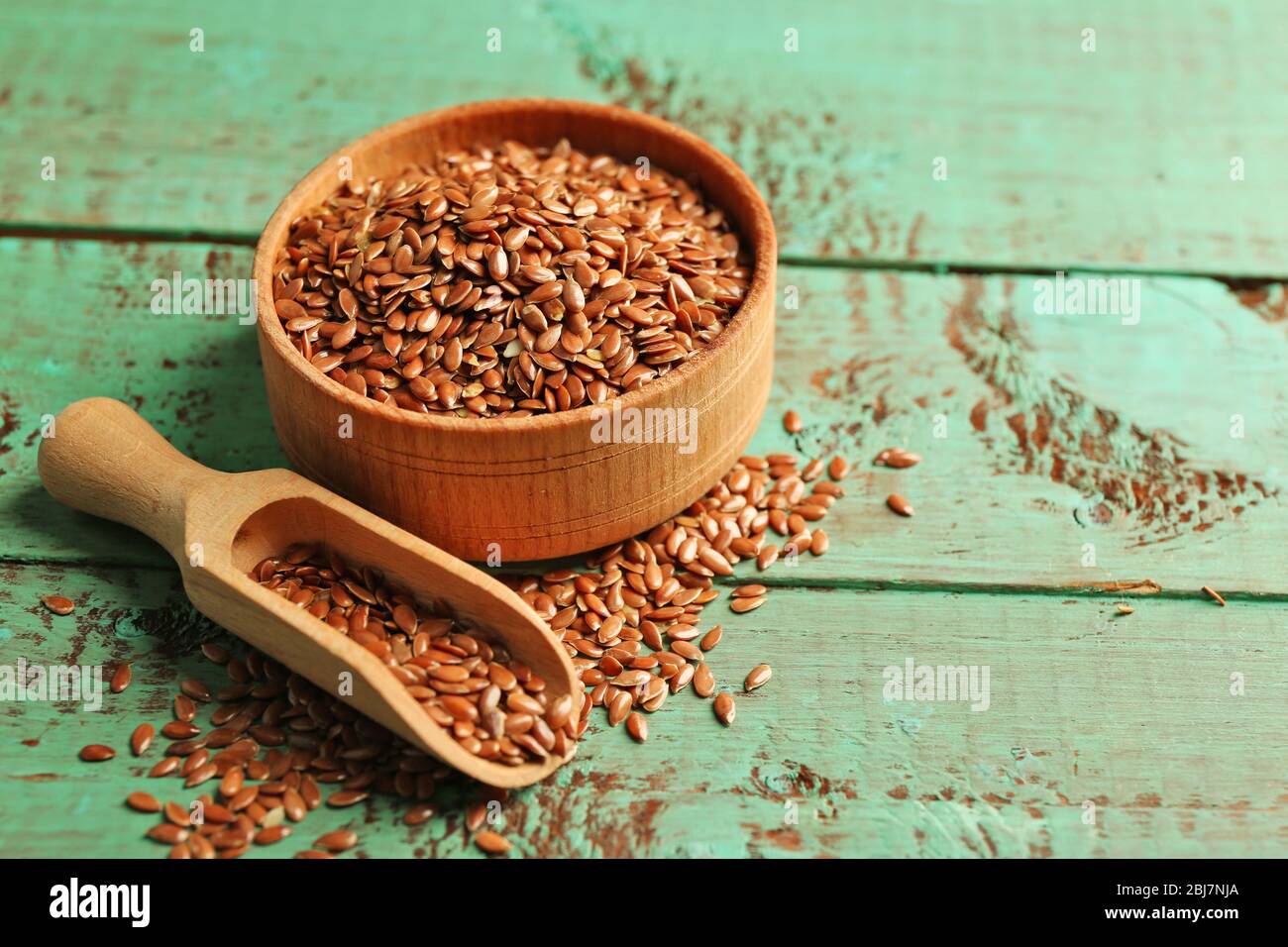 Flax seeds on green wooden table background, closeup Stock Photo - Alamy