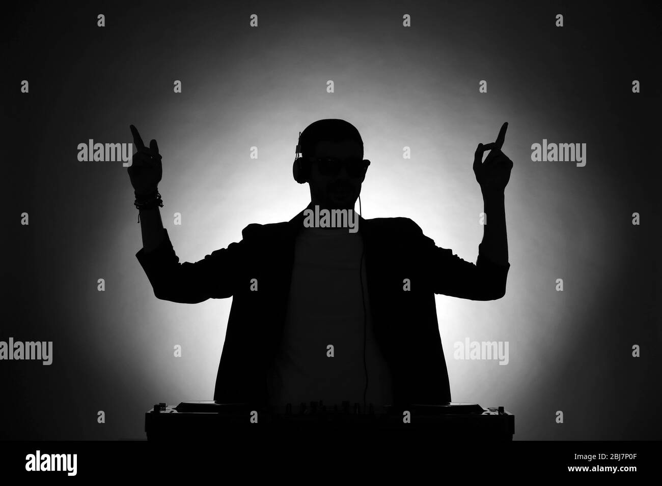 DJ playing music at mixer in dark Stock Photo - Alamy