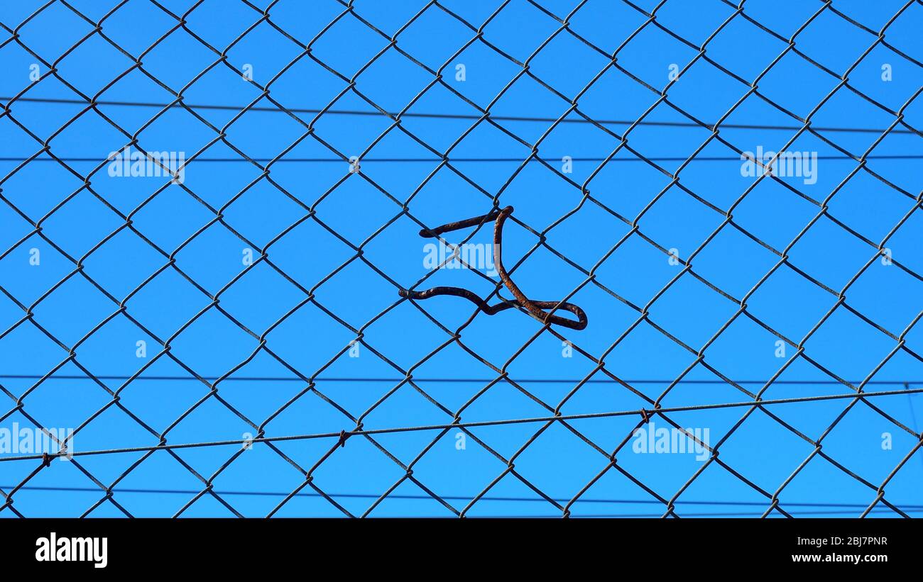 Cyclone mesh fence with rusty wire twist Stock Photo - Alamy
