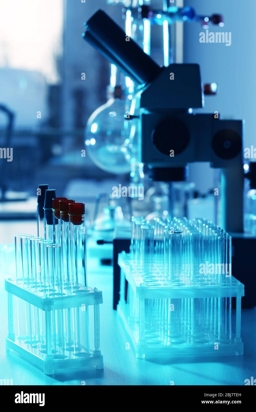 Microscope and different test tubes and flasks in laboratory Stock ...