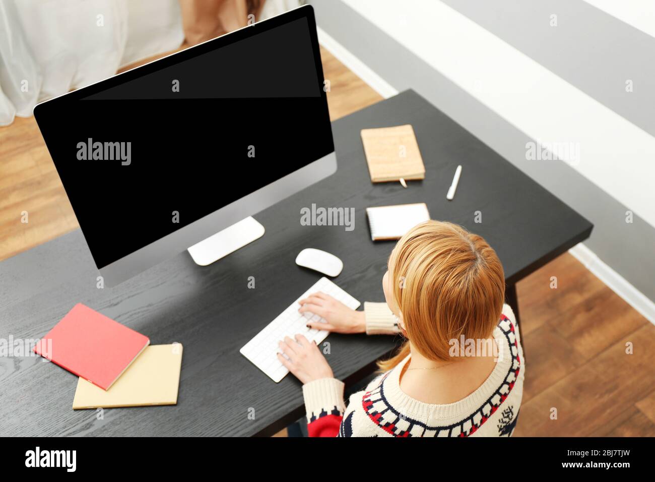 Back view of blond girl using modern computer in office Stock Photo - Alamy