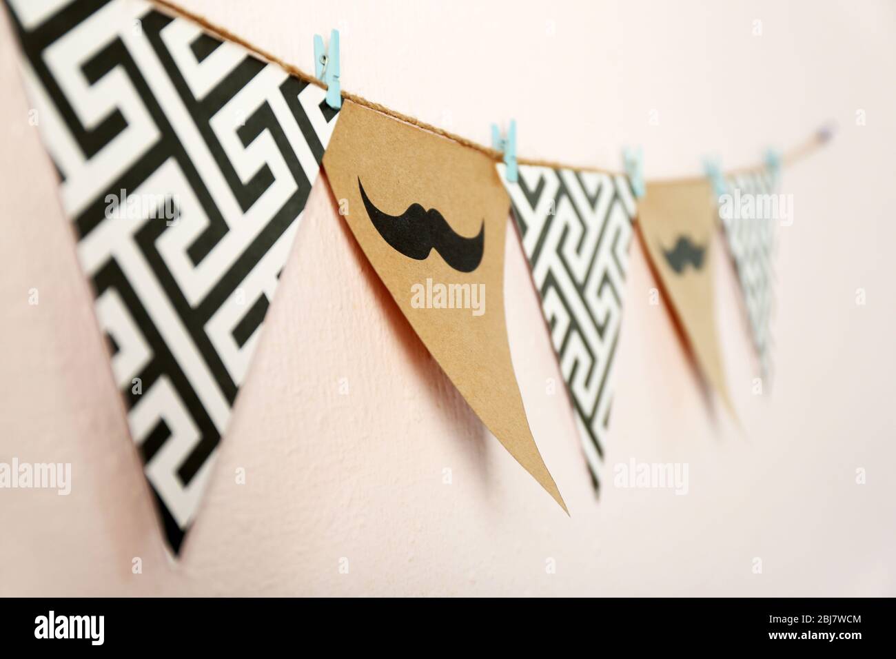 Triangle garland with mustache and pattern on wall Stock Photo - Alamy