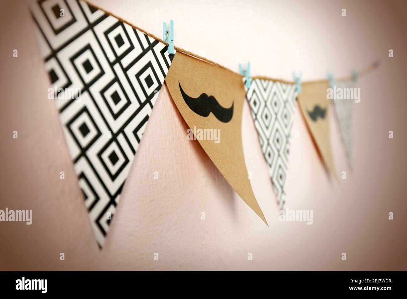 Triangle garland with mustache and pattern on wall Stock Photo - Alamy