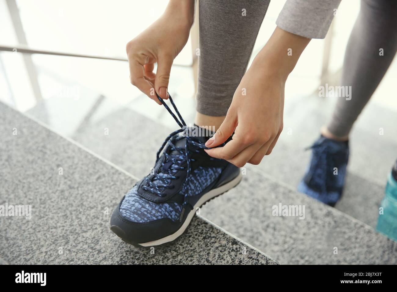 Woman tying up running shoe Stock Photo - Alamy