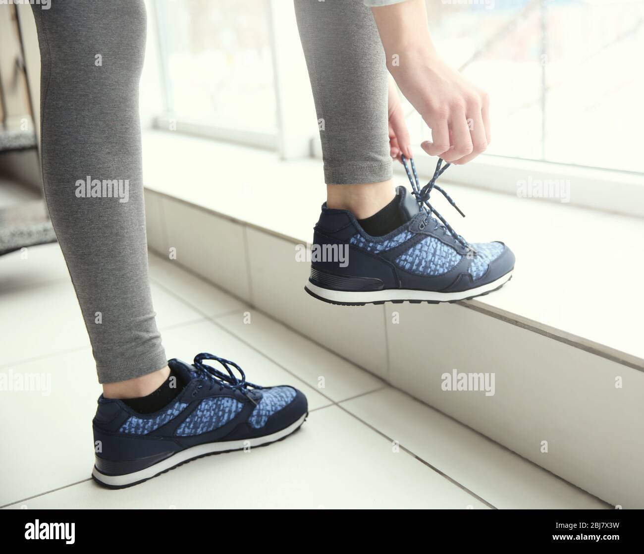Woman tying up running shoe Stock Photo - Alamy