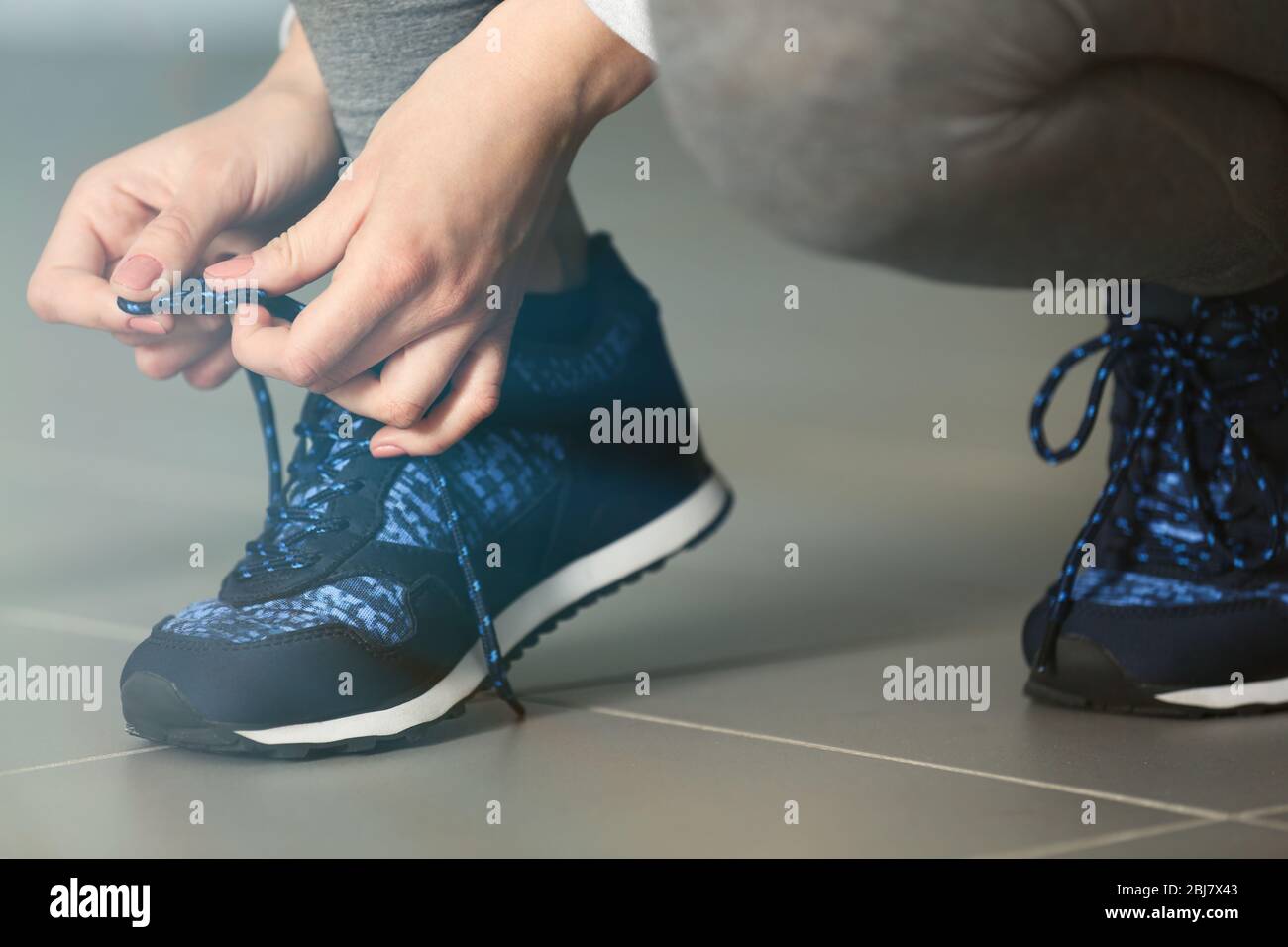 Woman tying up running shoe Stock Photo - Alamy
