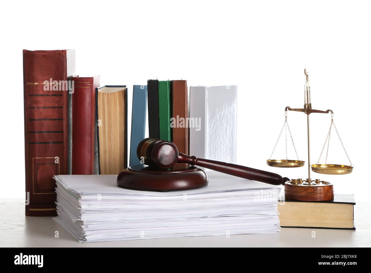 Wooden gavel with justice scales, stacks of documents and books on ...