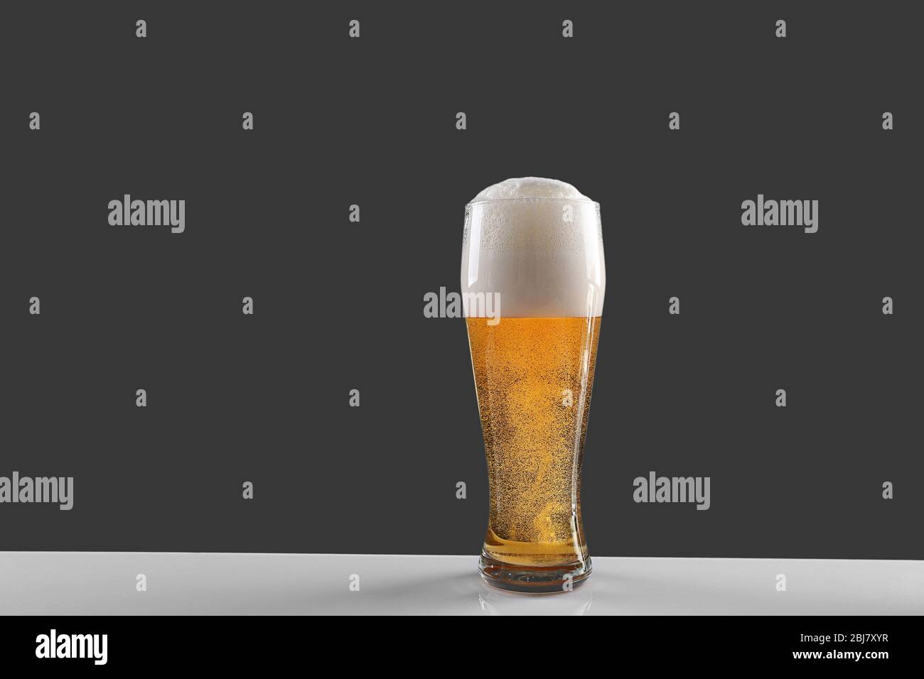 Glass of lager beer on grey background Stock Photo - Alamy