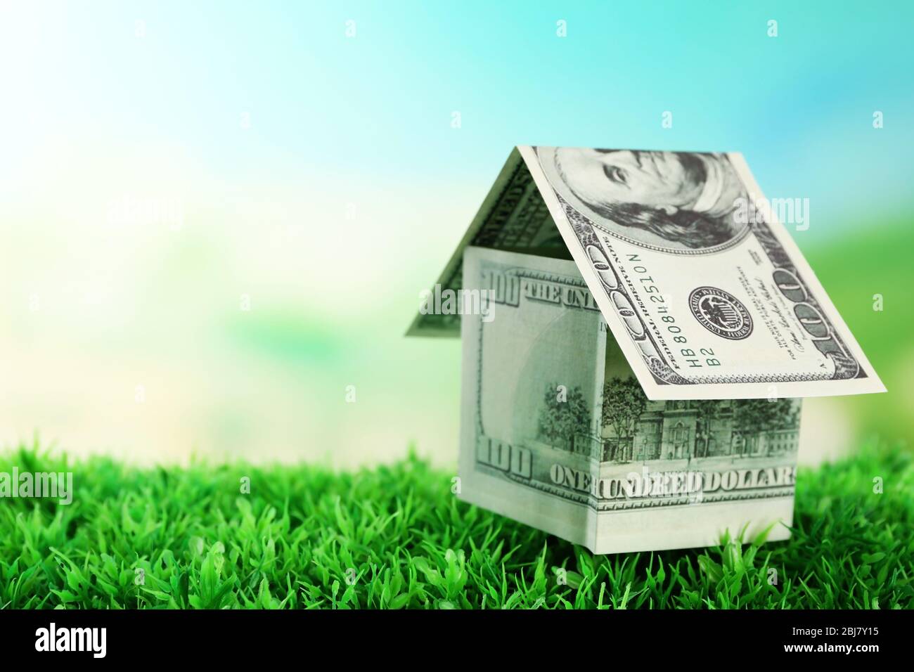 Money house on green grass, close up Stock Photo - Alamy