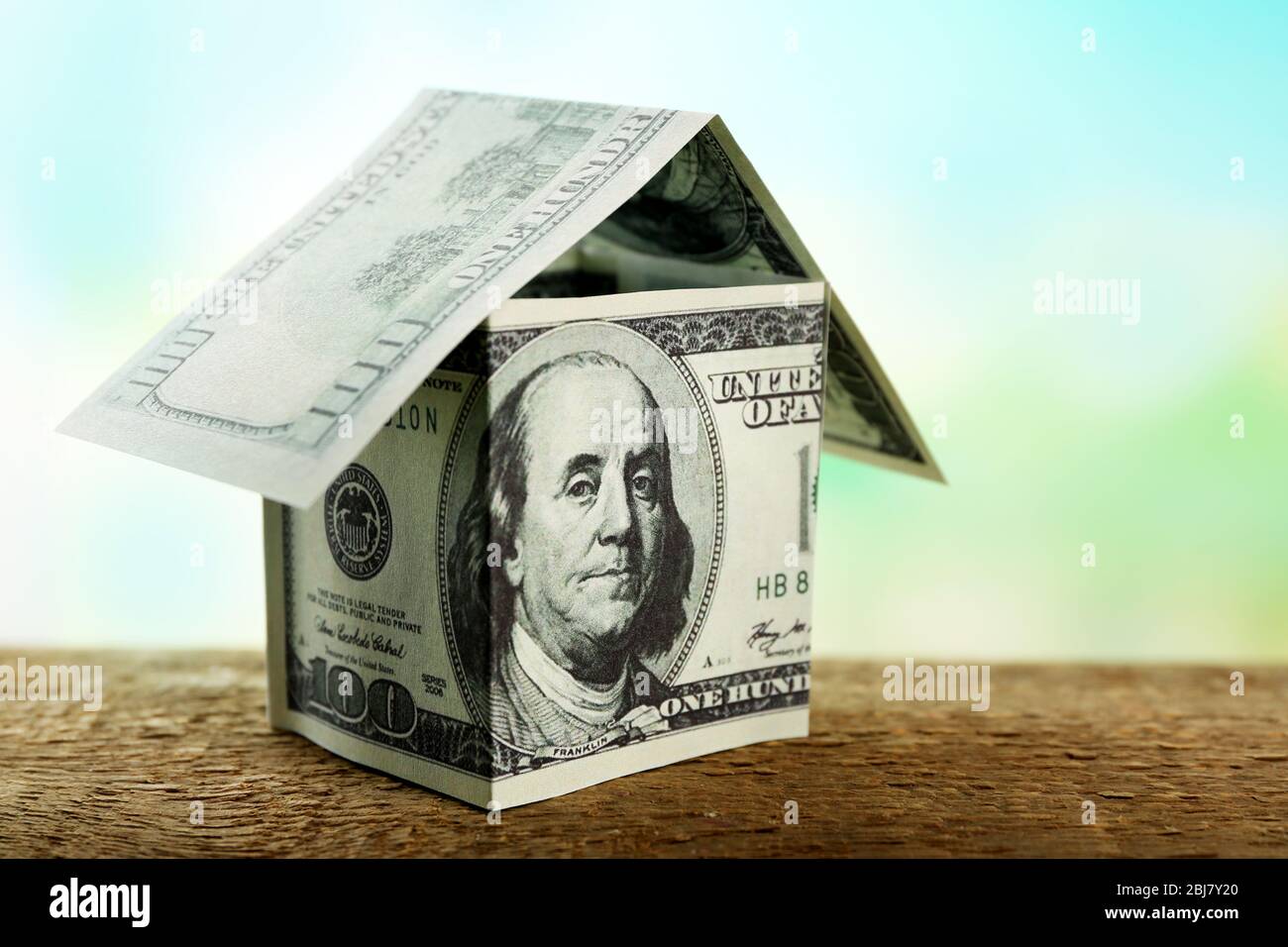 Money house on wooden surface, close up Stock Photo - Alamy