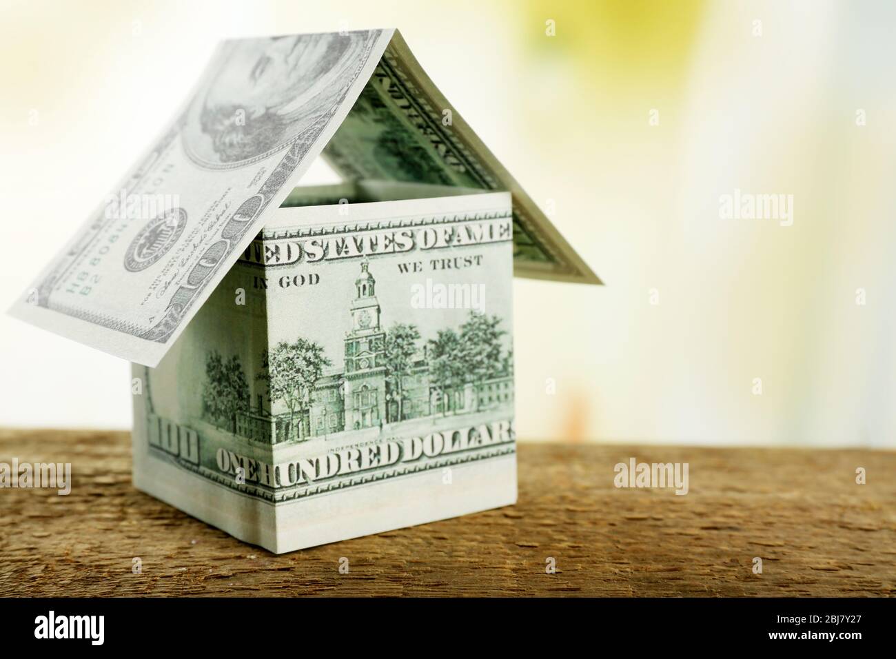 Money house on wooden surface, close up Stock Photo - Alamy
