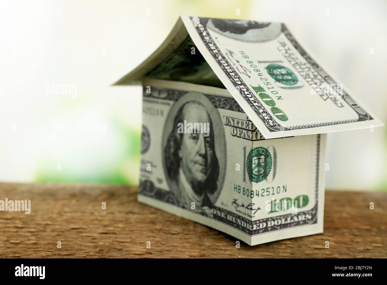 Money house on wooden surface, close up Stock Photo - Alamy