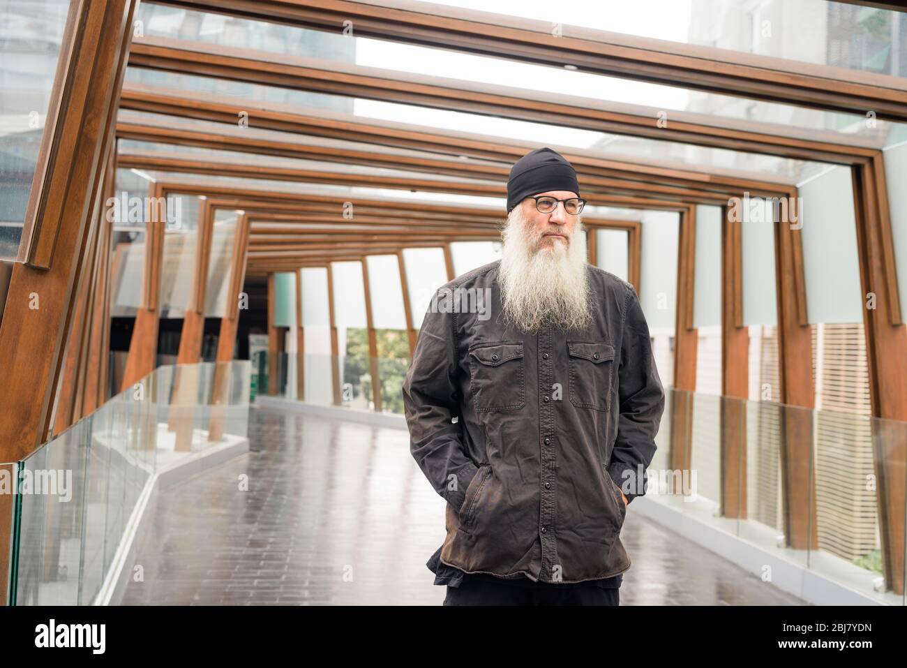 Mature bearded man thinking at footbridge in the city Stock Photo - Alamy