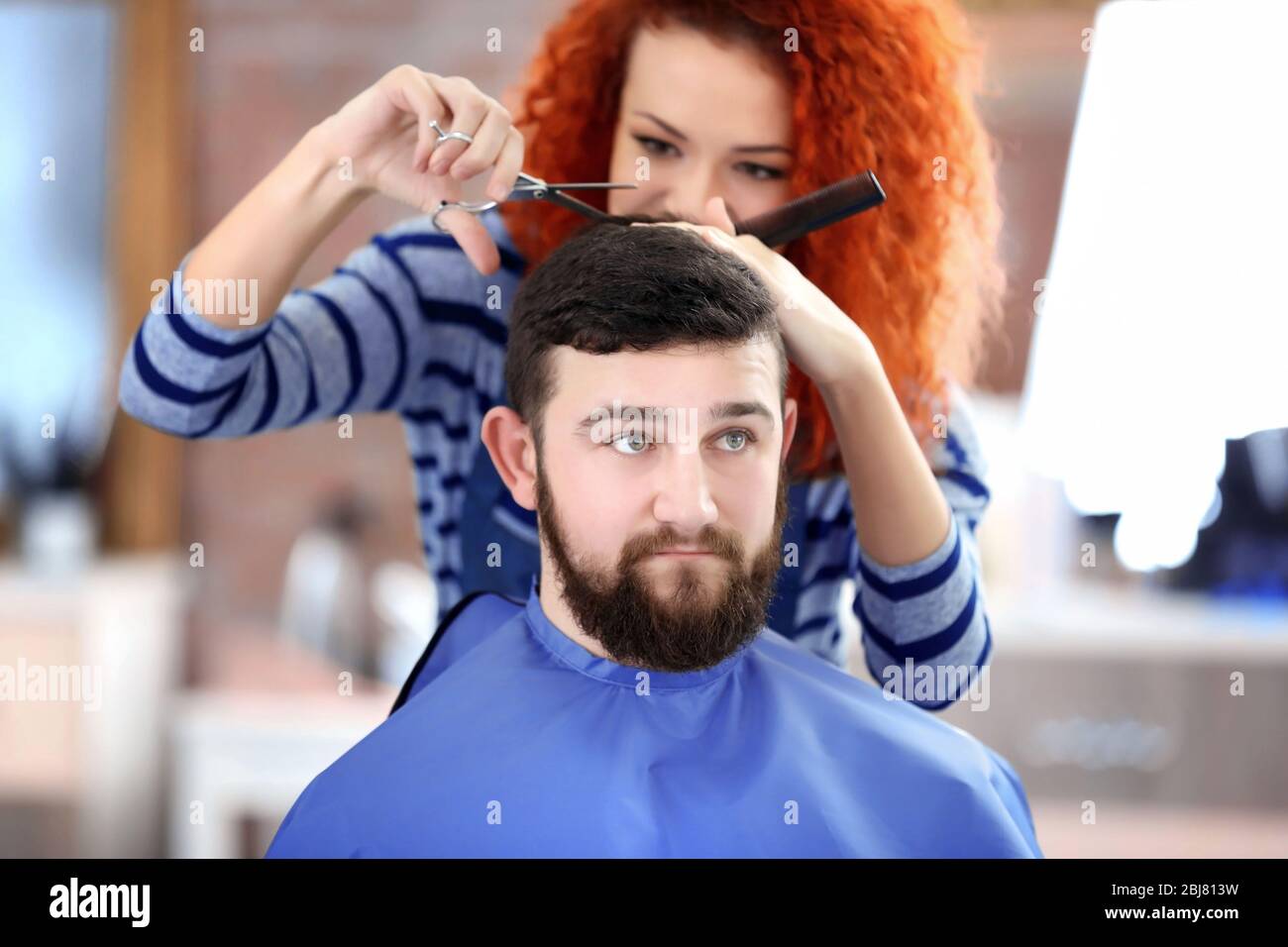 Professional hairdresser making new haircut her handsome client Stock ...