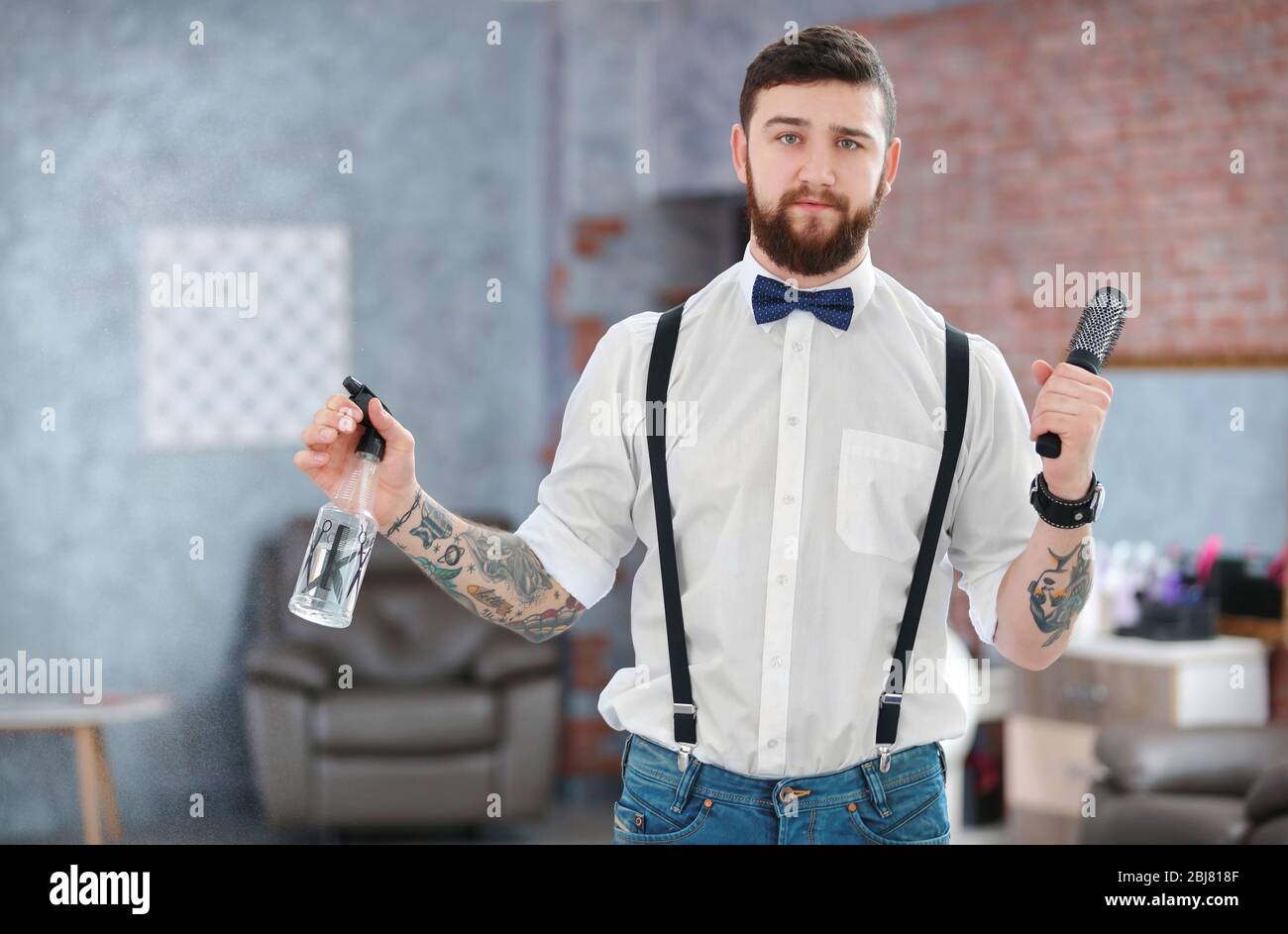 Stylish barber with spray and comb Stock Photo - Alamy