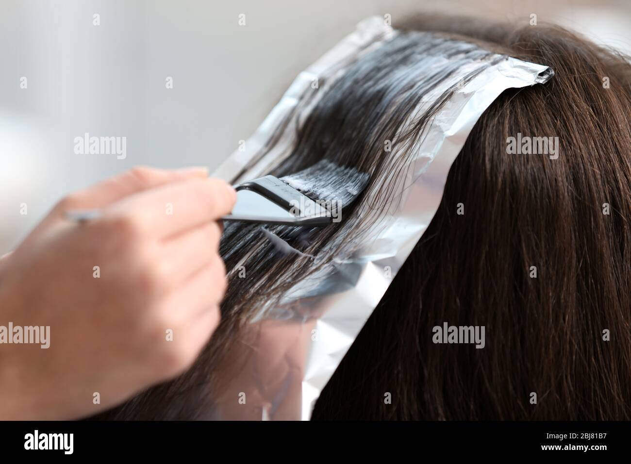 Professional hairdresser coloring hair Stock Photo - Alamy