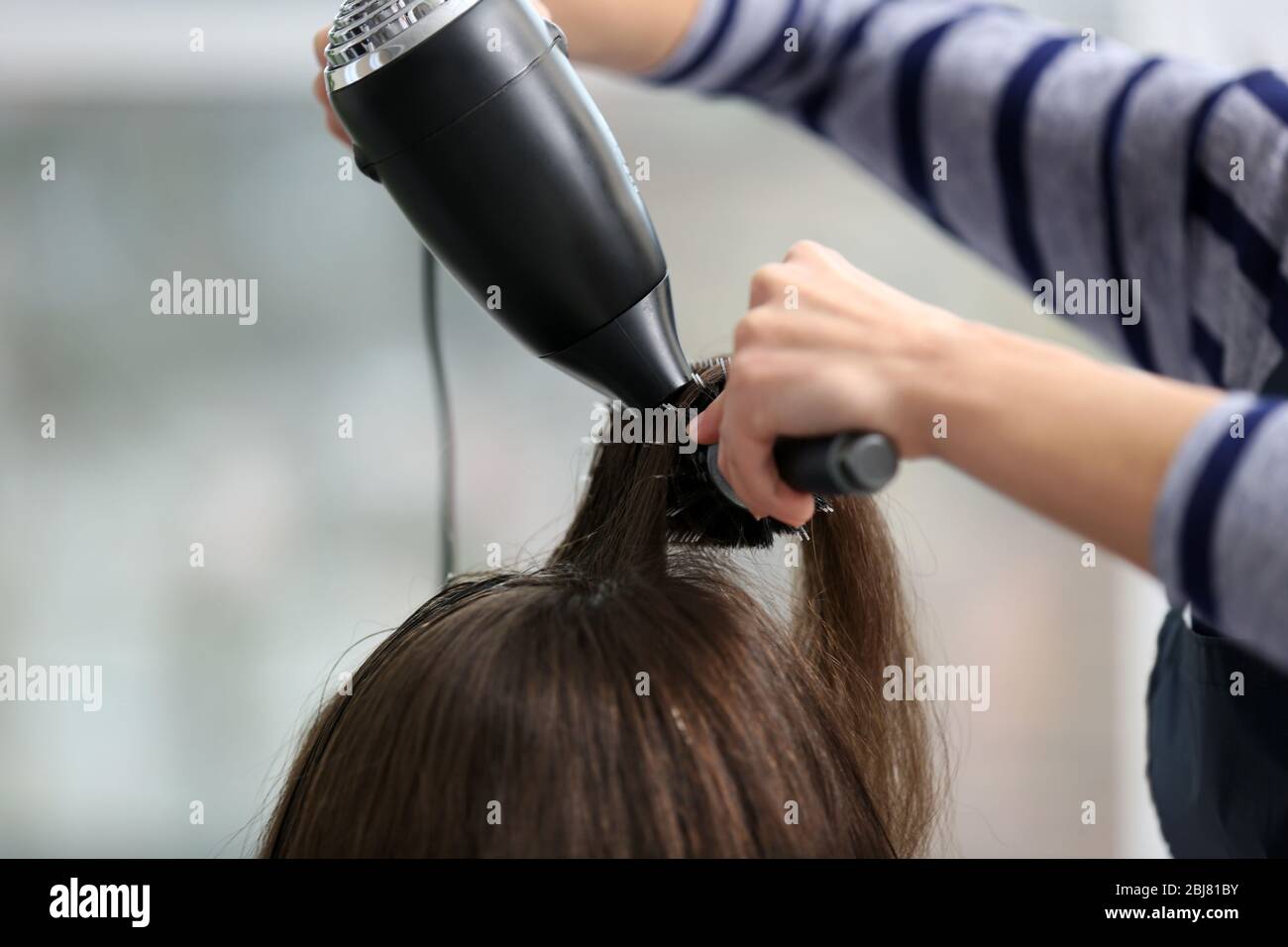 Professional hairdresser drying hair Stock Photo - Alamy