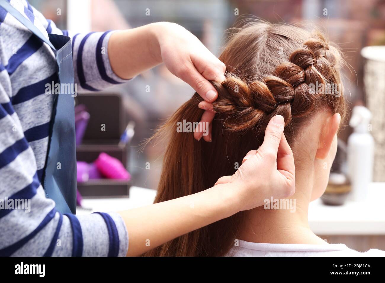 Professional hairdresser braiding clients hair Stock Photo - Alamy