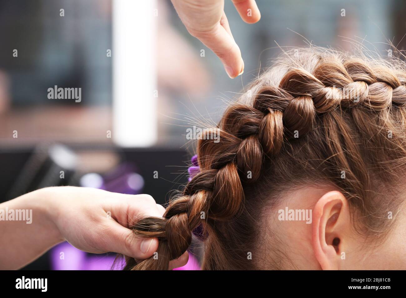 Professional hairdresser braiding clients hair Stock Photo - Alamy