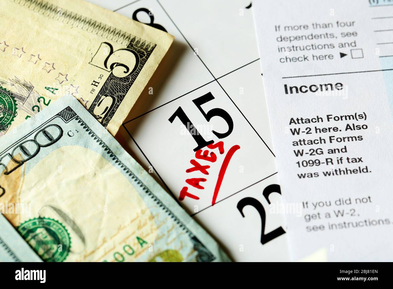 A red tax mark in the calendar, tax form with dollar bills, close up ...