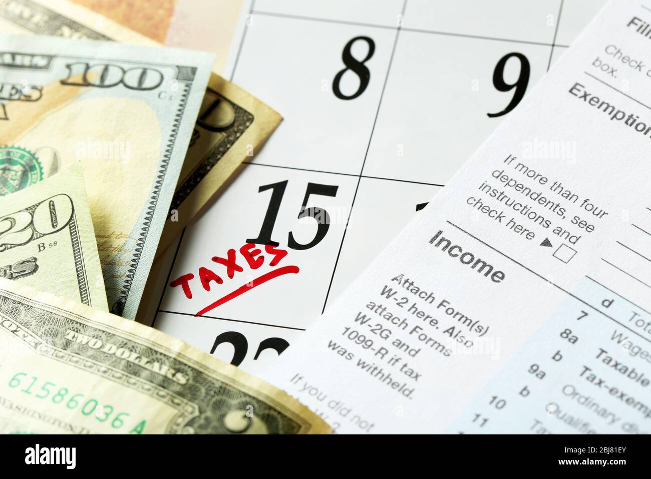 A red tax mark in the calendar, tax form with dollar bills, close up ...