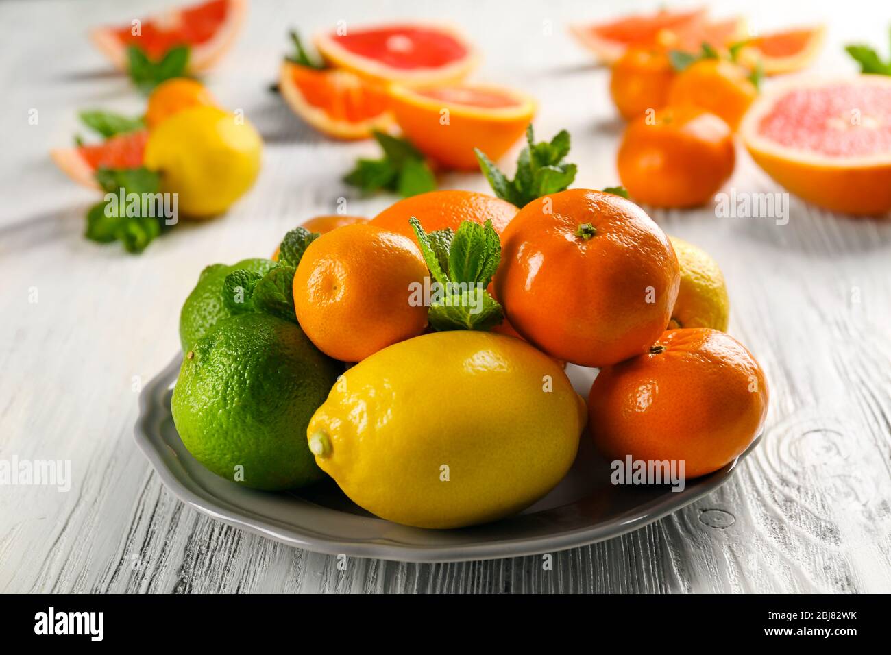 Set of different citrus fruit on light wooden table Stock Photo - Alamy