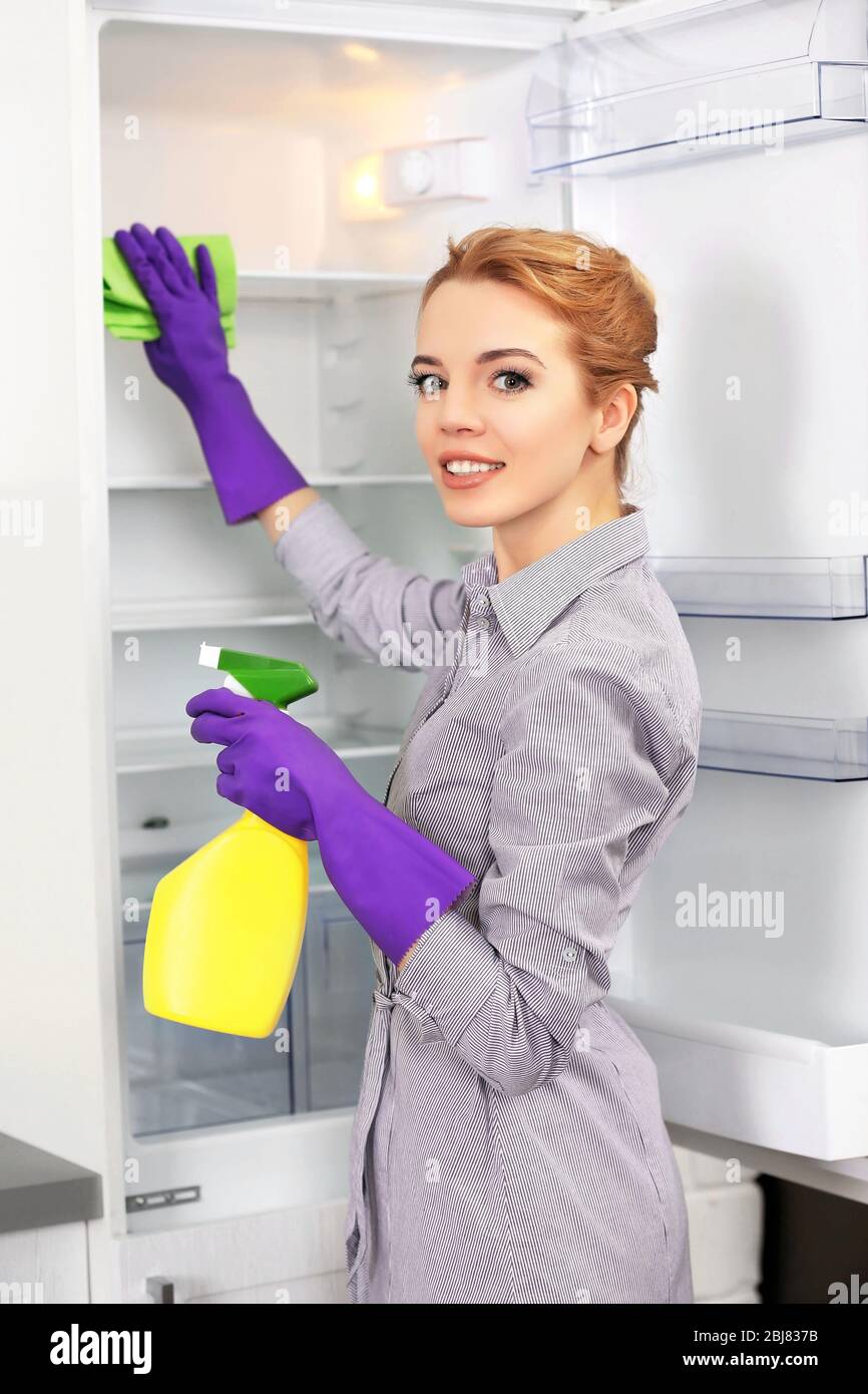 Young woman cleaning empty fridge with a sponge Stock Photo - Alamy