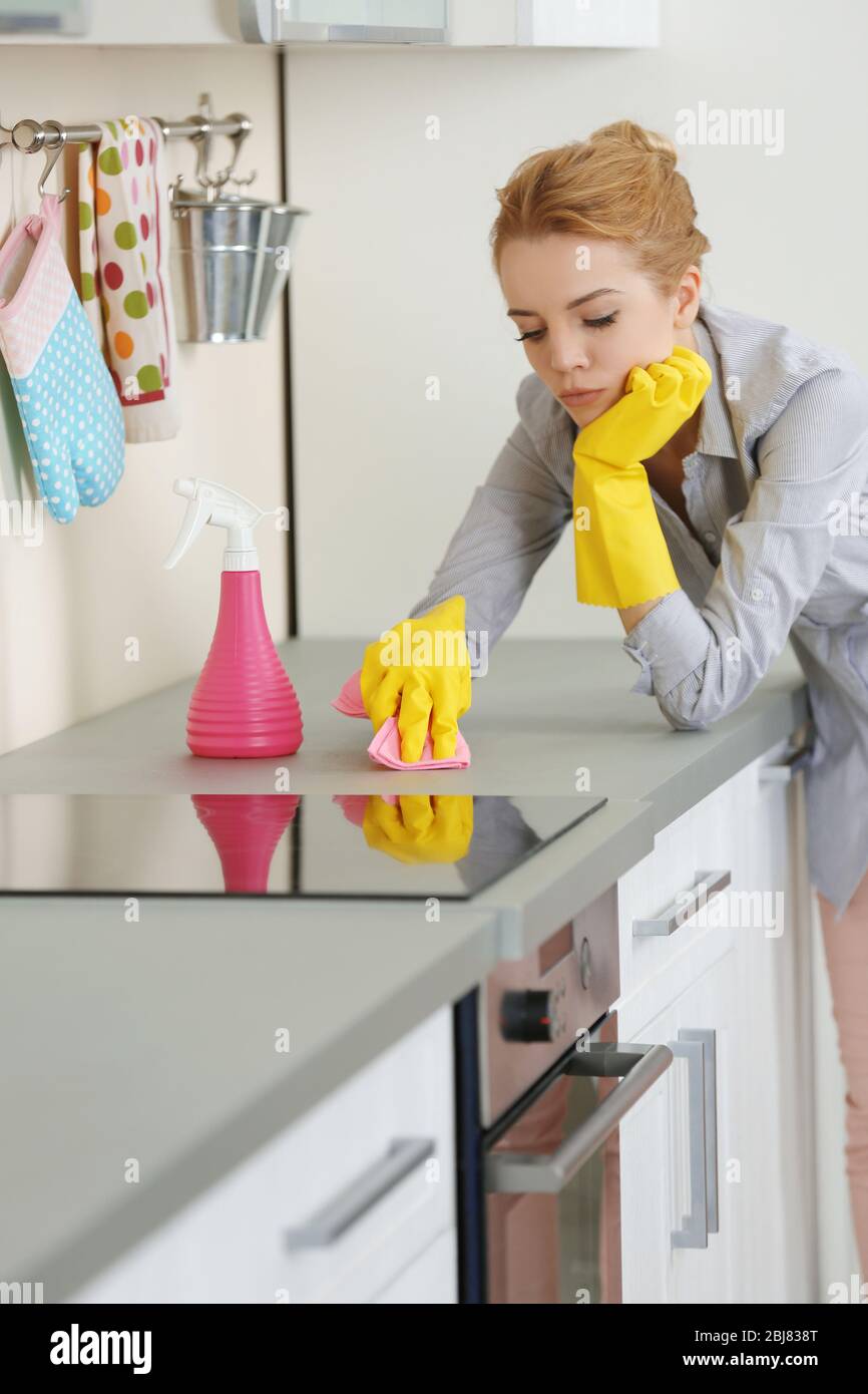 Young woman scrubbing the kitchen counter with a rag Stock Photo - Alamy