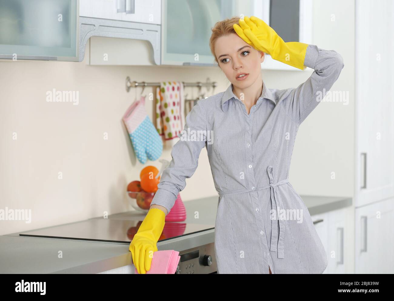 Tired woman after cleaning the kitchen Stock Photo - Alamy