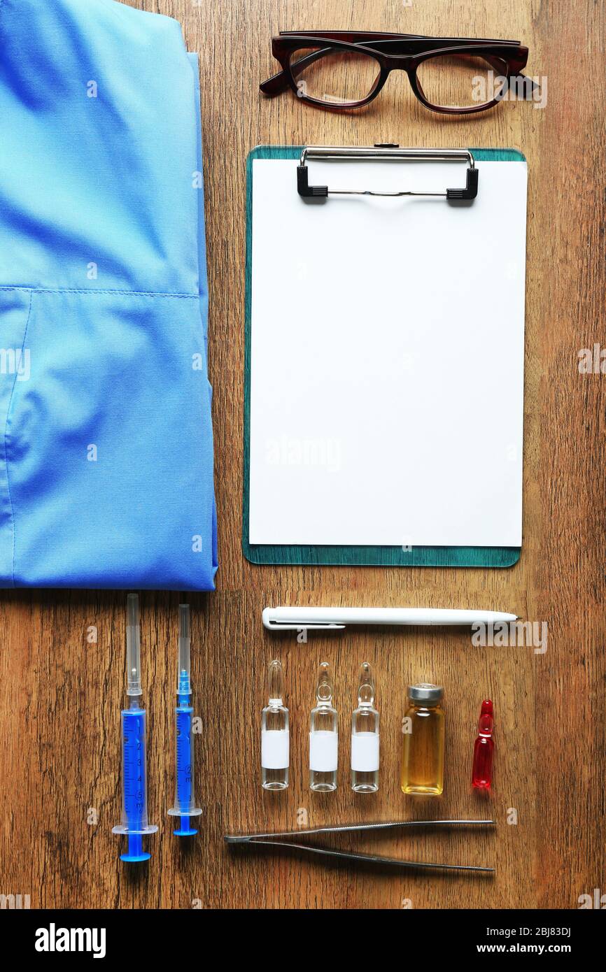 Doctor table with medicines and uniform, top view Stock Photo - Alamy