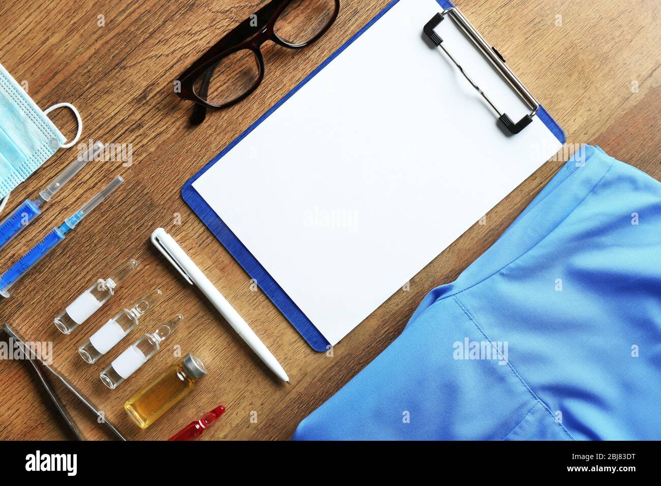 Doctor table with medicines and uniform, top view Stock Photo - Alamy